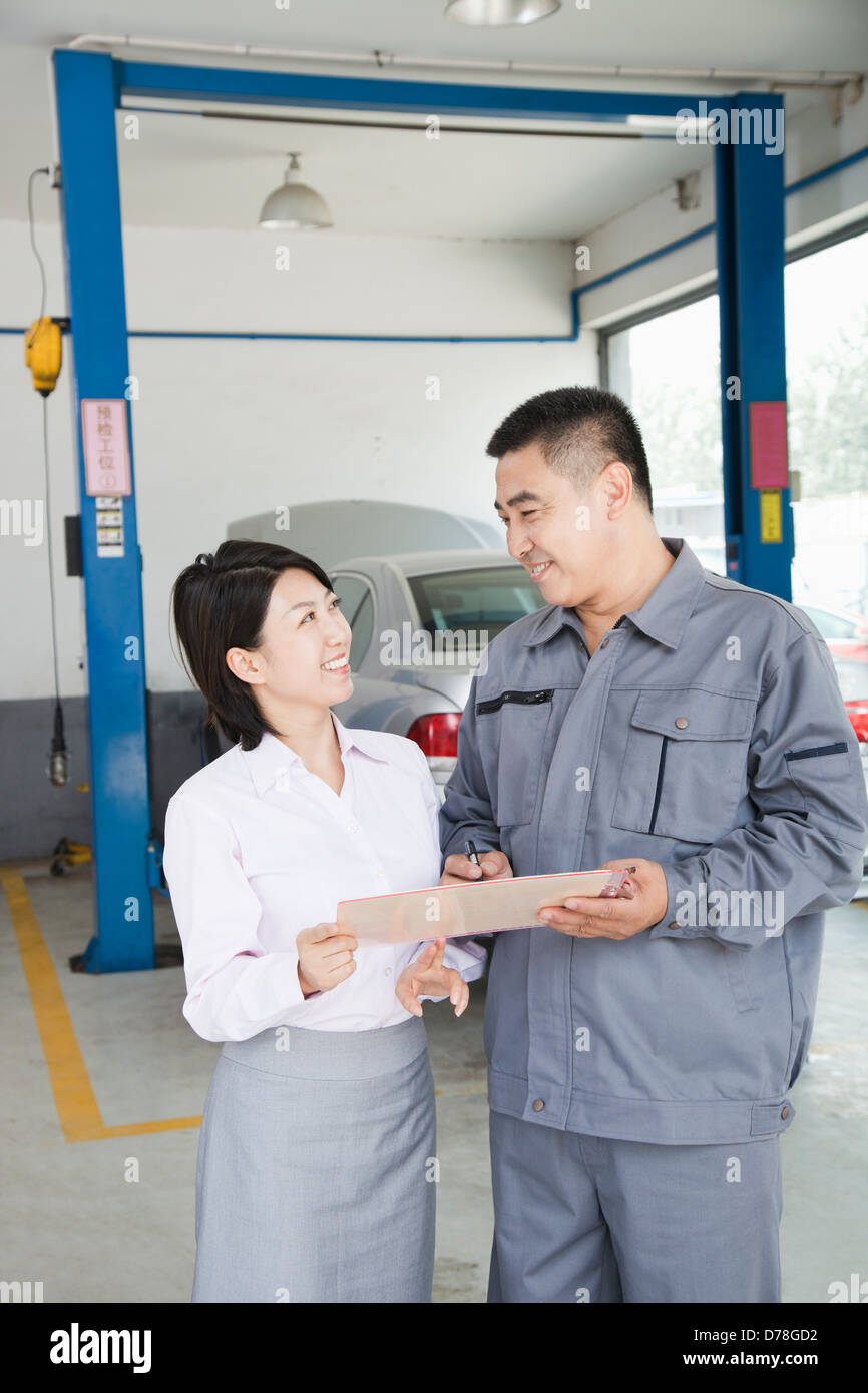 Garage Mechanic Explaining to Customer Stock Photo - Alamy