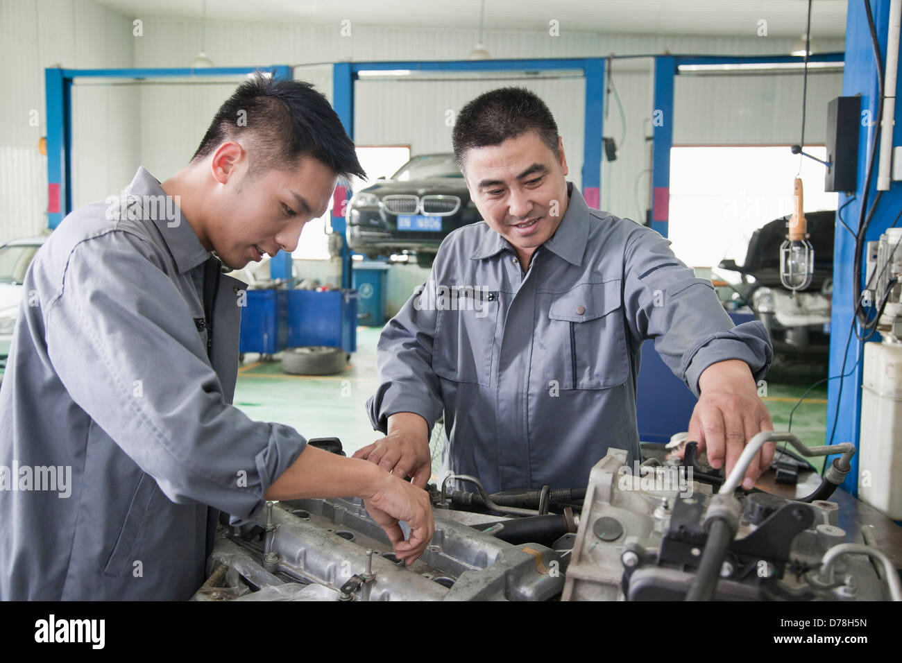 Two Mechanics Working on Car Engine Stock Photo - Alamy