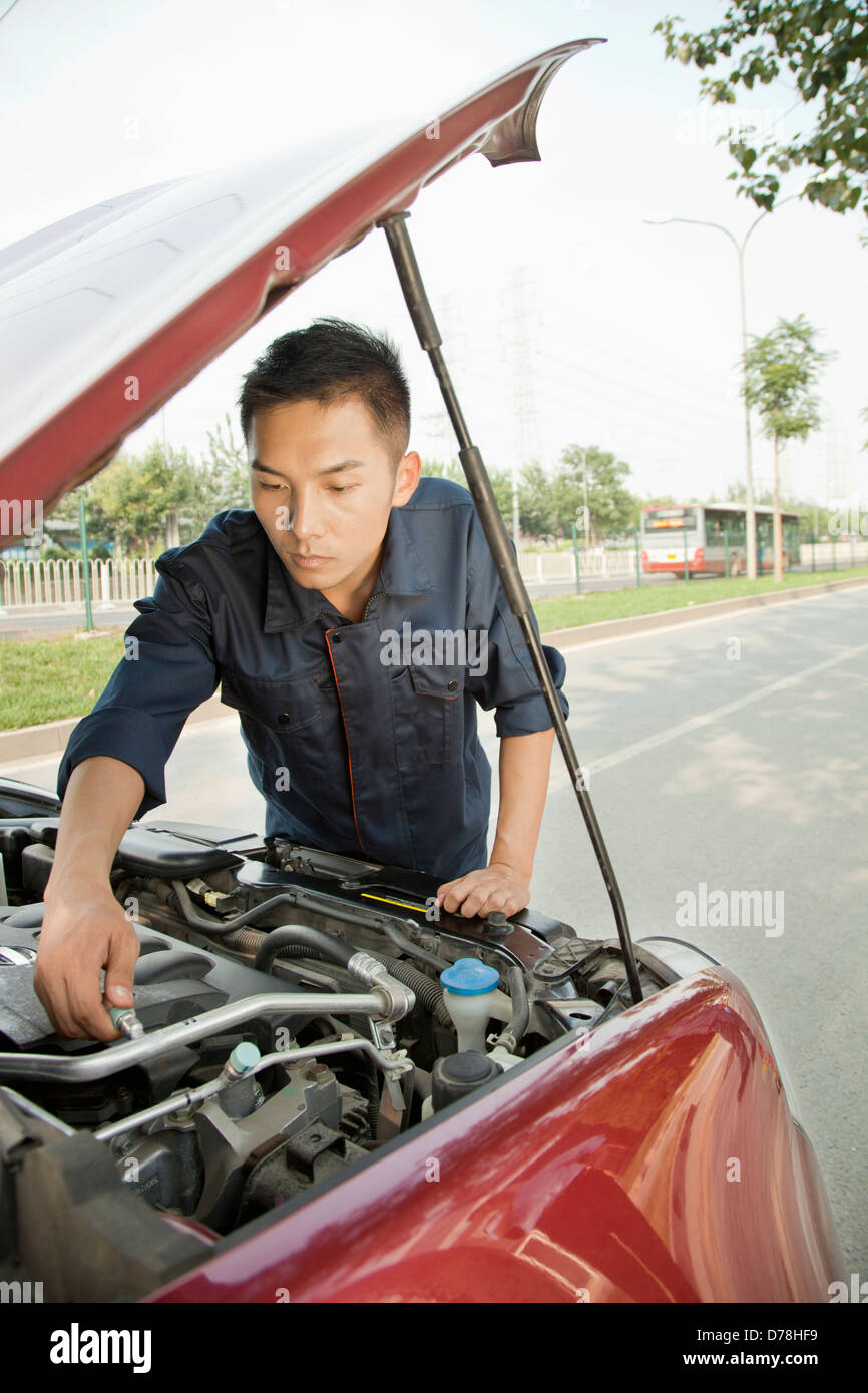 Mechanic Fixing Car by Roadside Stock Photo - Alamy