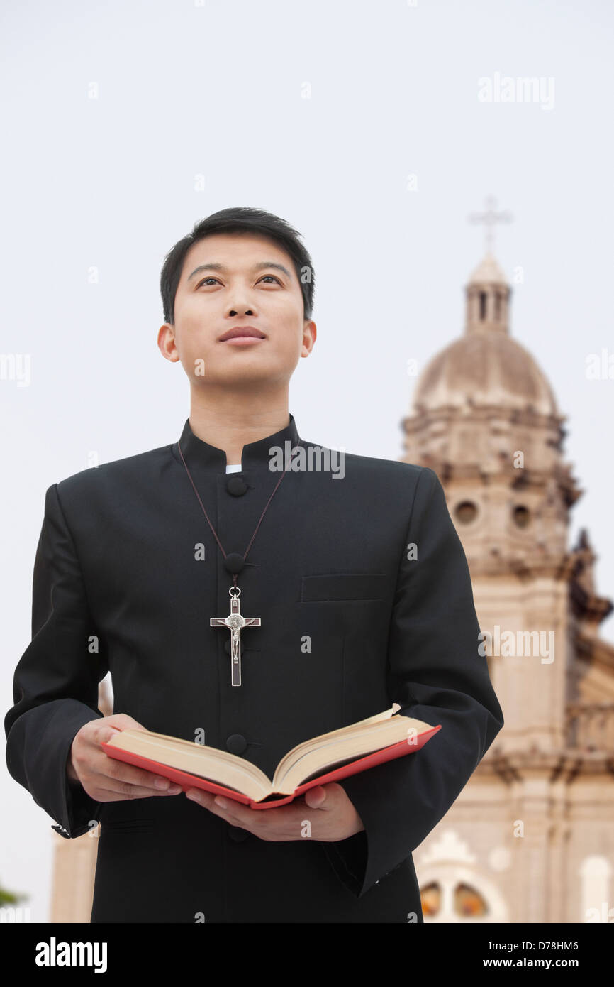 Young Priest Looking to Sky in Front Of Church Stock Photo - Alamy
