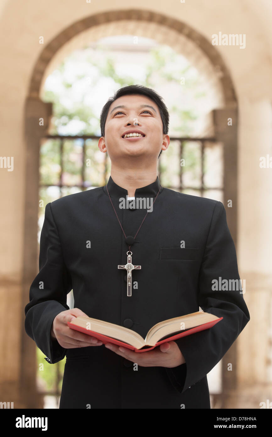 Young Priest Looking to Sky in Front of Doorway Stock Photo - Alamy