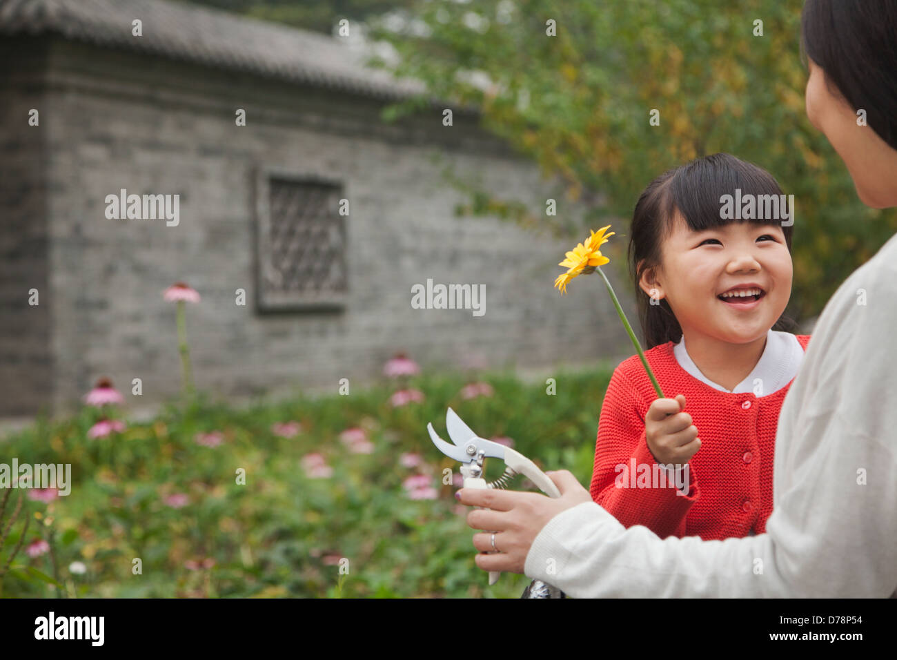 Smiling young girl with flower Stock Photo - Alamy