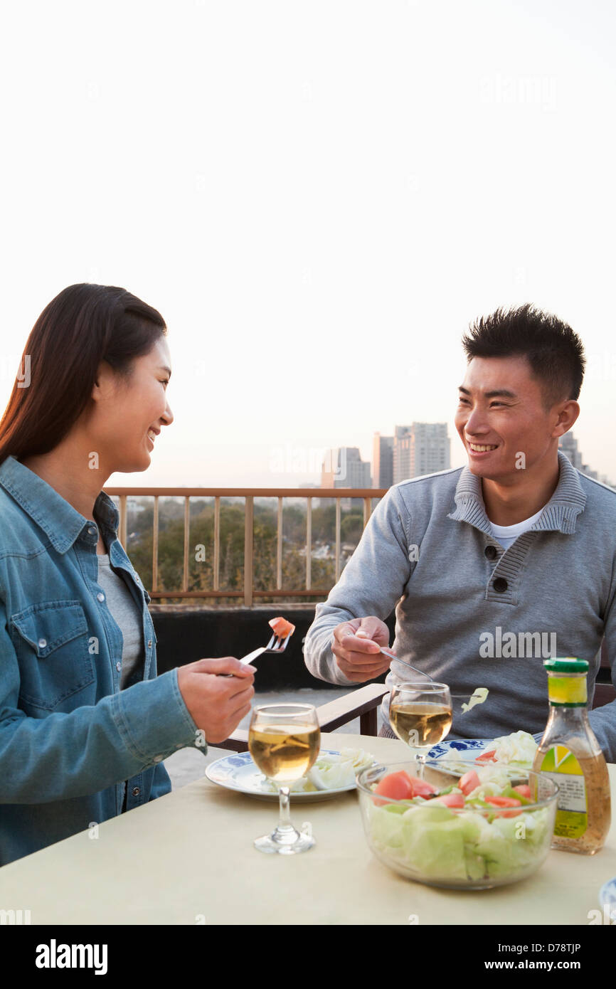 Young couple eating on the roof top Stock Photo - Alamy