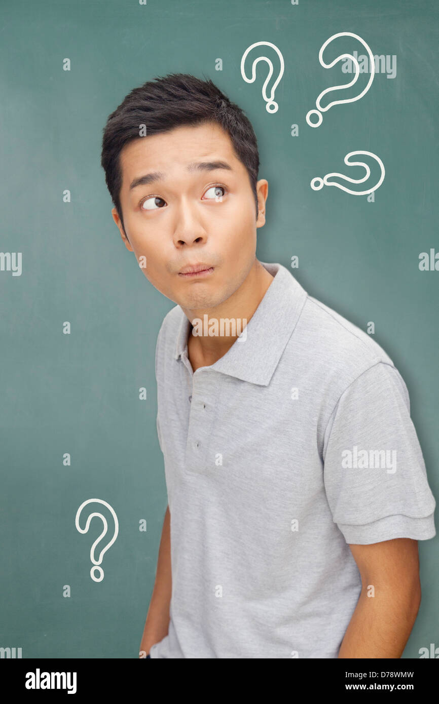 Portrait young man in front of blackboard with question marks Stock ...