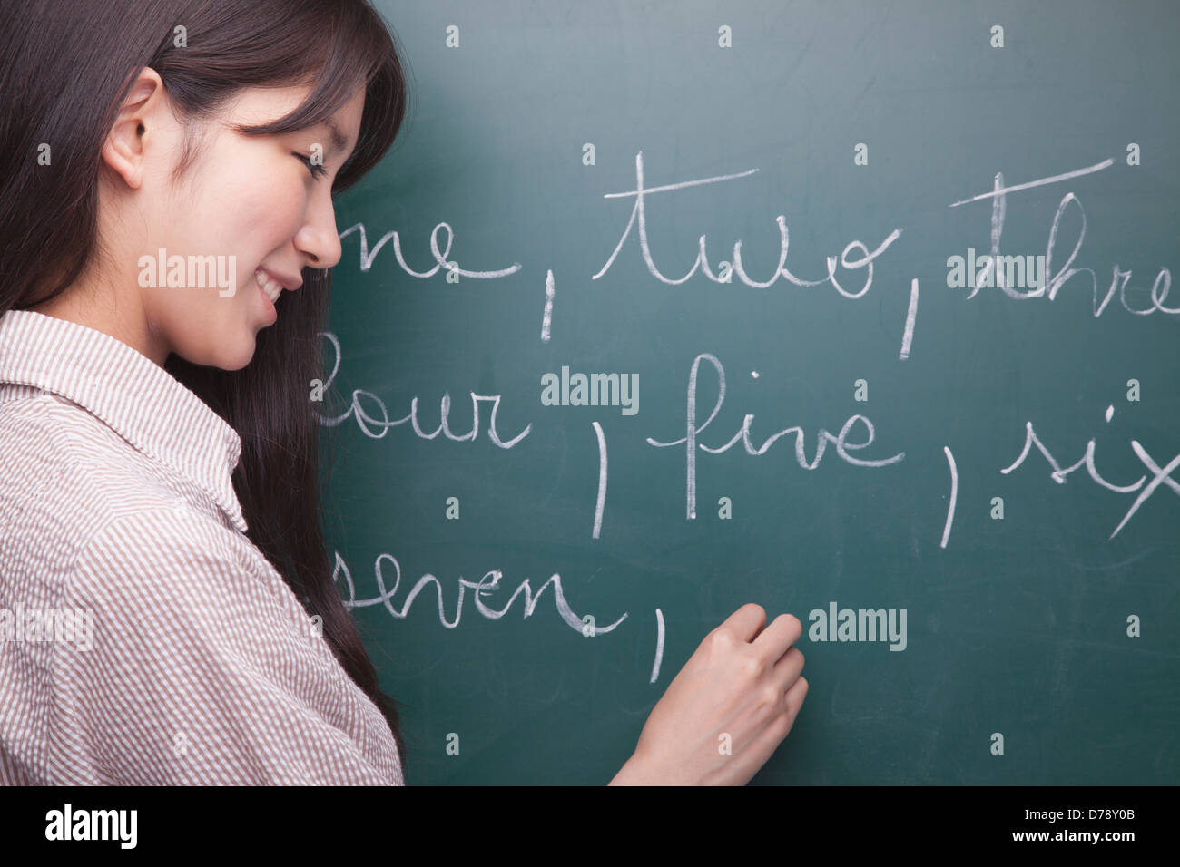 Young woman student writing English numbers on blackboard Stock Photo ...