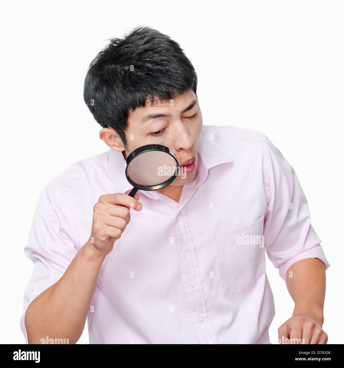 Young man looking through magnifying glass Stock Photo - Alamy