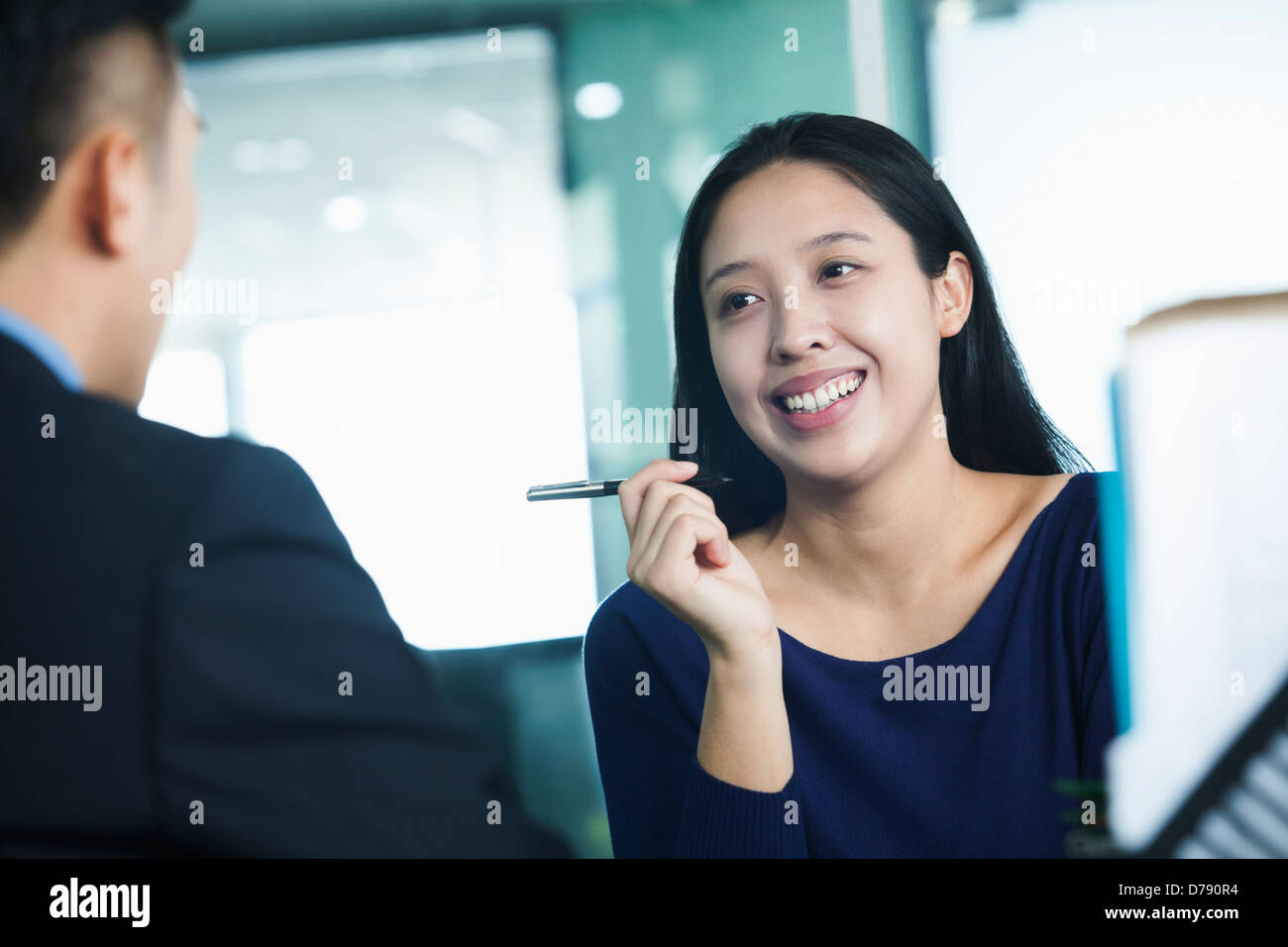 Two co-workers talking in office Stock Photo - Alamy