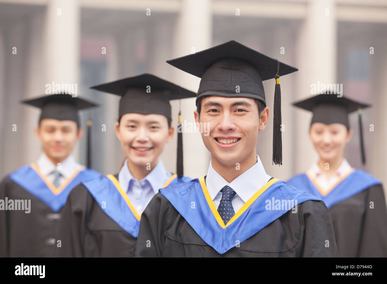 Four University Graduates Smiling, Looking at Camera Stock Photo - Alamy