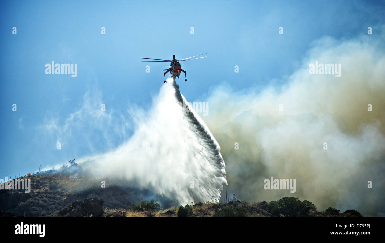 A firefighting helicopter douses a southern California wildfire north ...