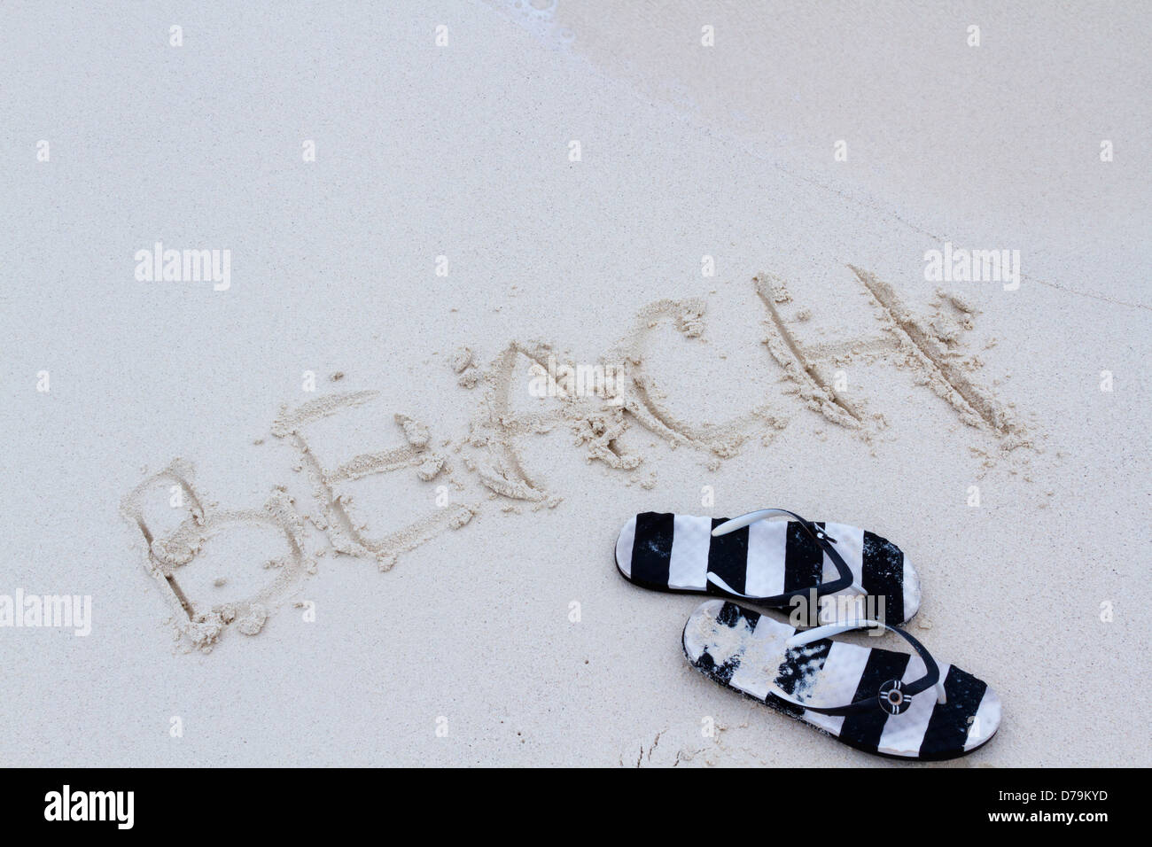 Beach written on the beach with wave Stock Photo - Alamy