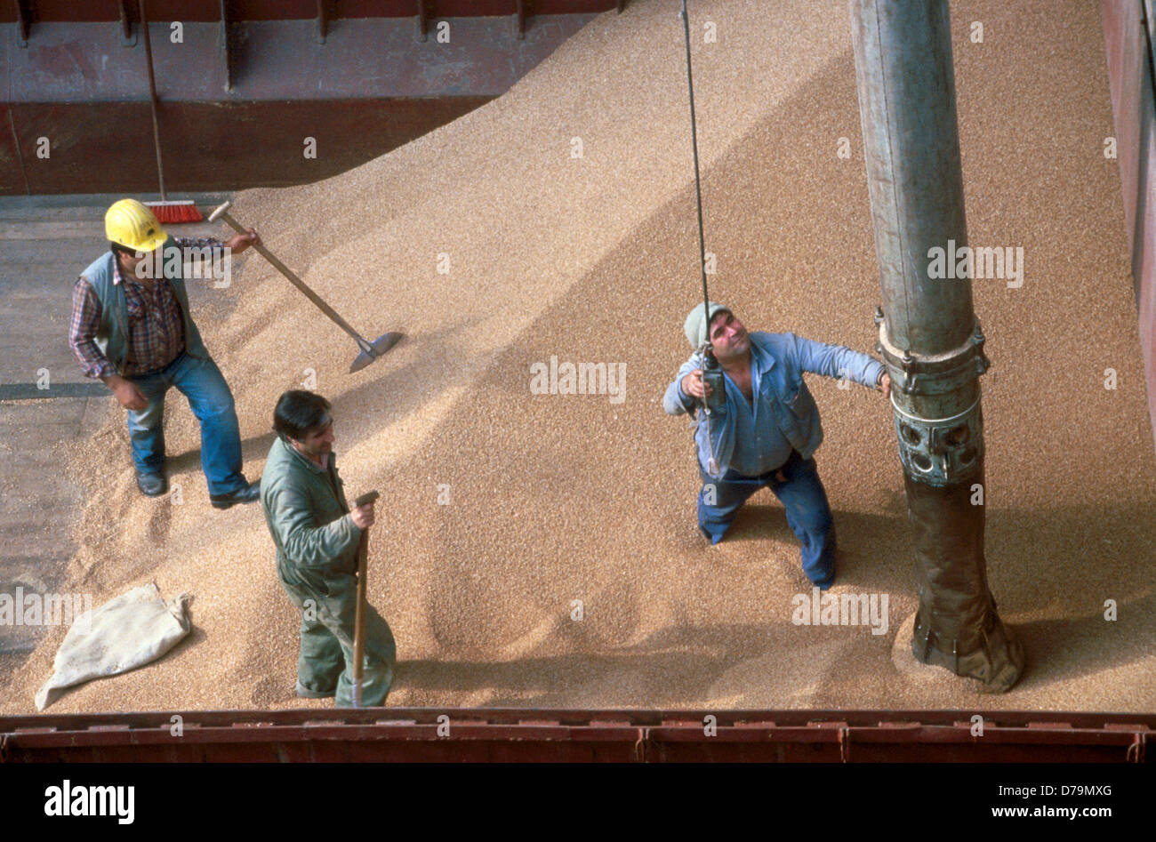 Men unloading ship soya meal through suction tube Stock Photo - Alamy