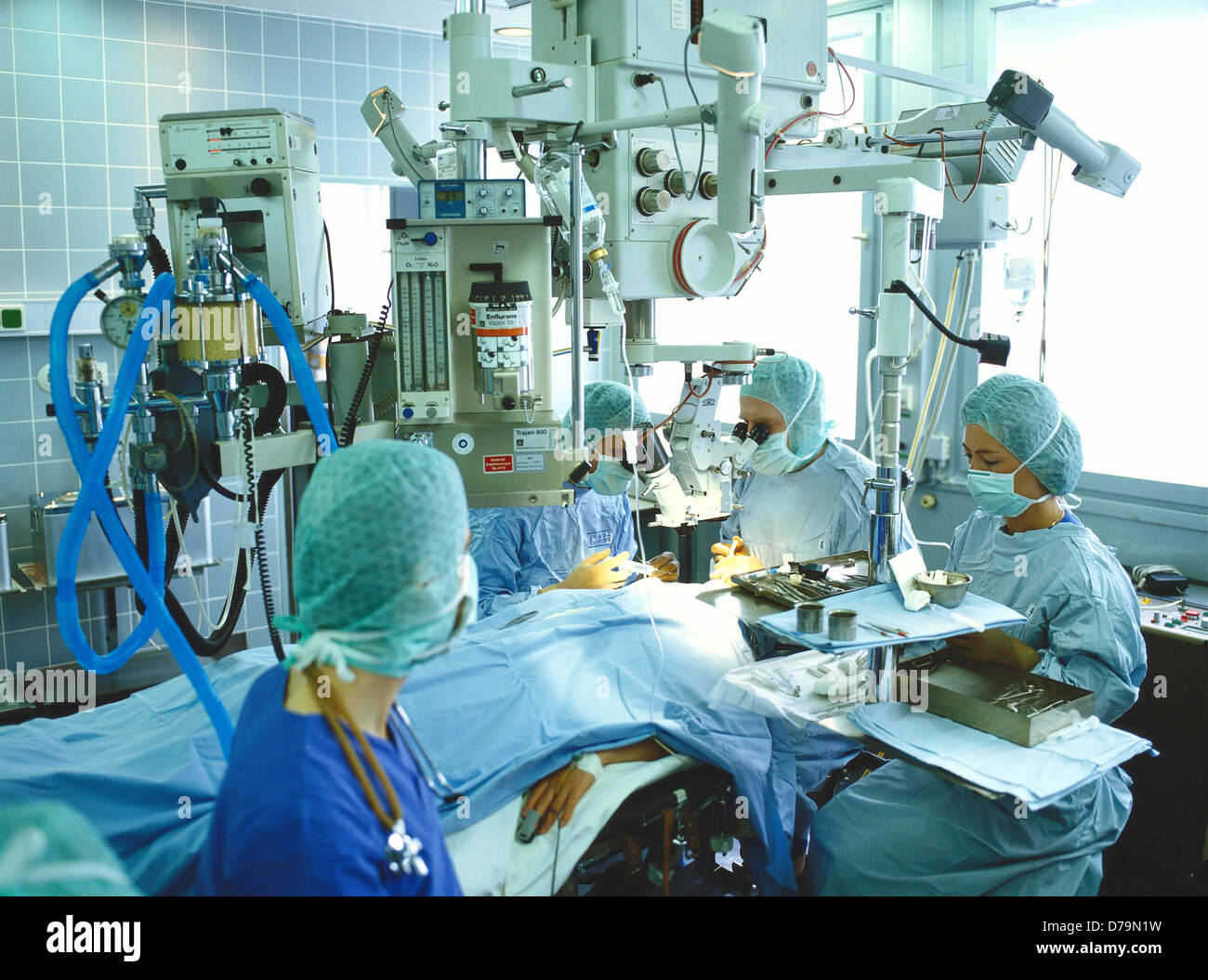 Two surgeons looking through binocular microscope while doing ...