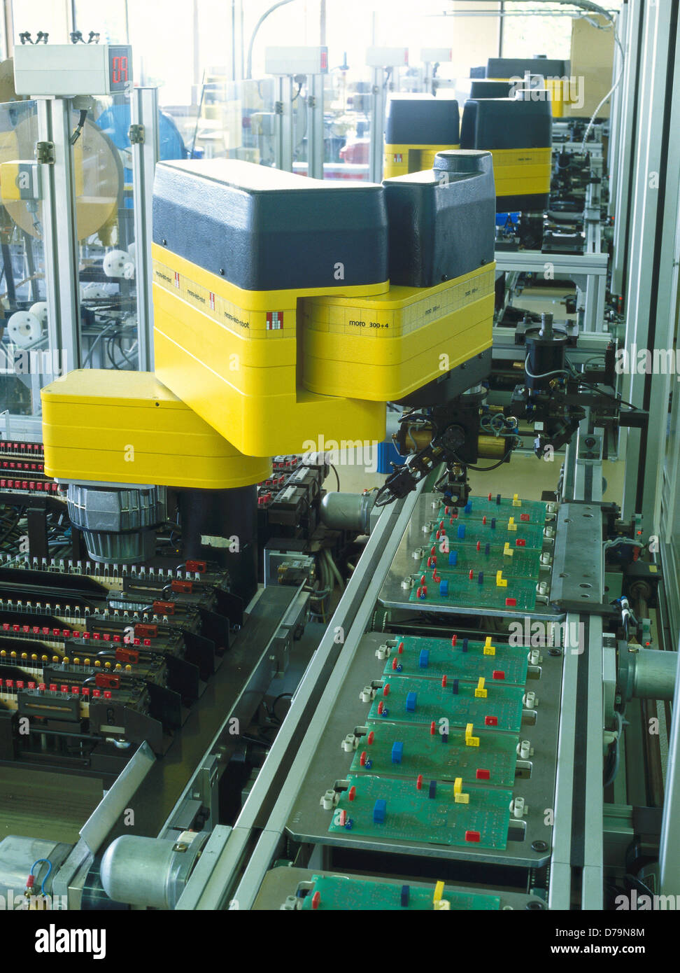 Robots inserting electronic components into printed circuit boards ... Robots inserting electronic components into printed circuit boards ...