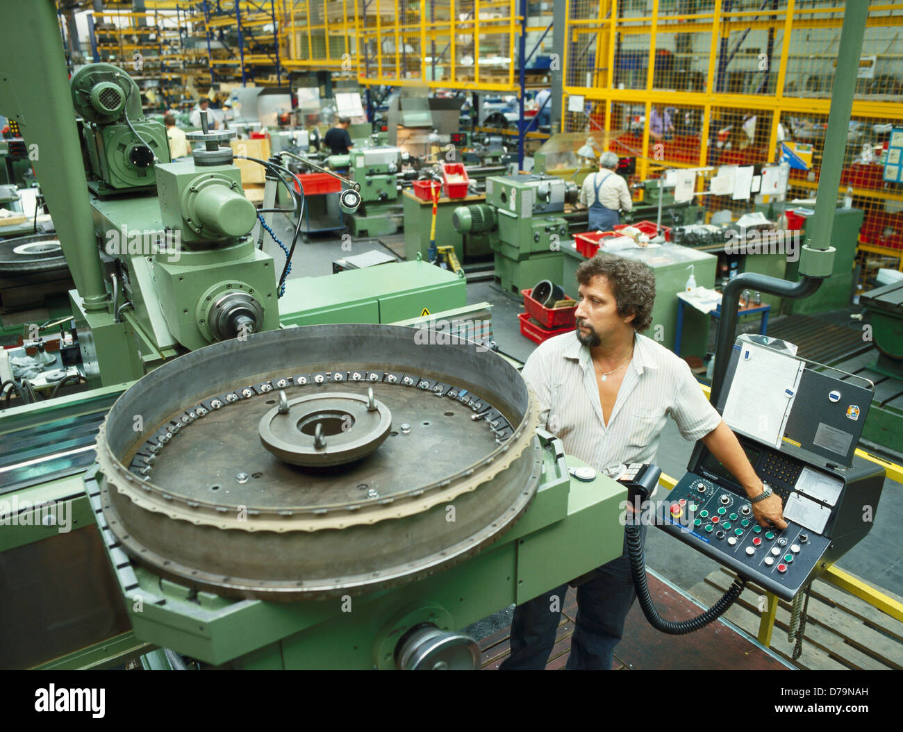 Operator at cnc milling machine machining turbine section jet engine ...