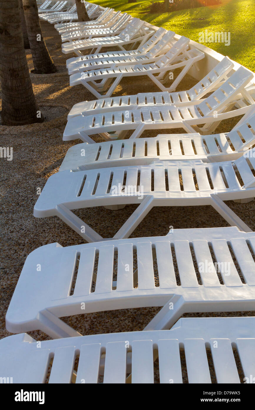 White pool chairs near the swimming pool at vacation resort in Mexico ...
