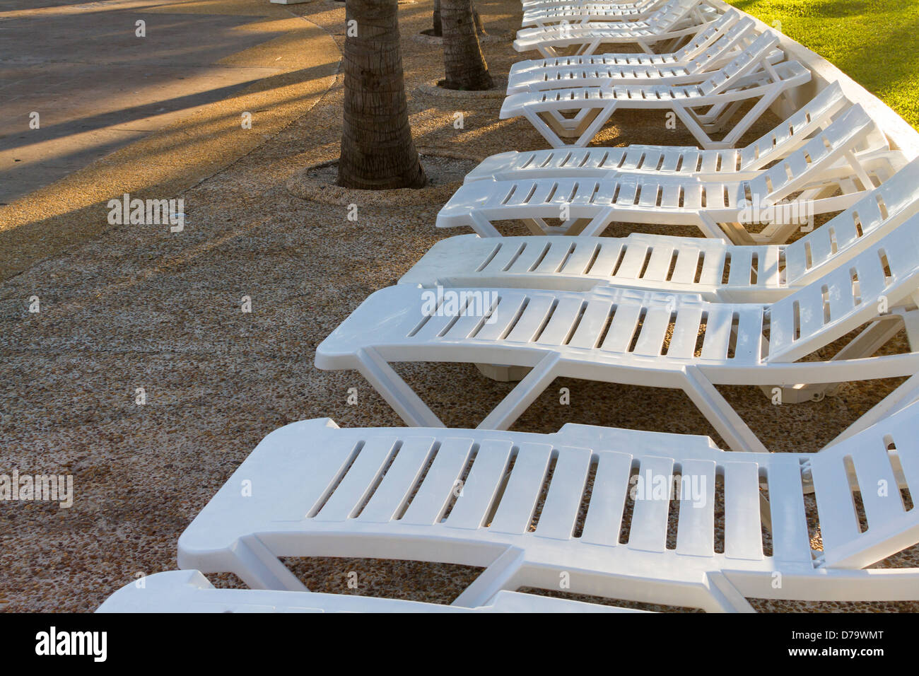 White pool chairs near the swimming pool at vacation resort in Mexico ...
