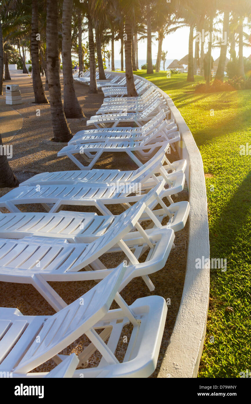 White pool chairs near the swimming pool at vacation resort in Mexico ...