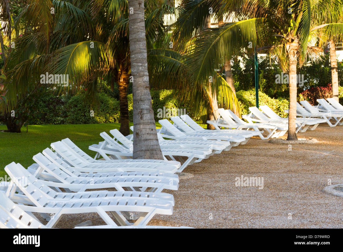 White pool chairs near the swimming pool at vacation resort in Mexico ...