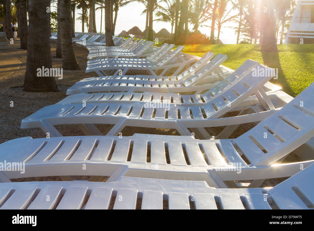 White pool chairs near the swimming pool at vacation resort in Mexico ...