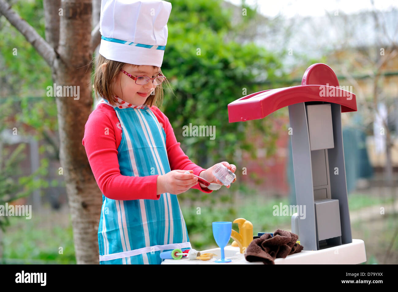 little girl playing cooking in garden Stock Photo - Alamy