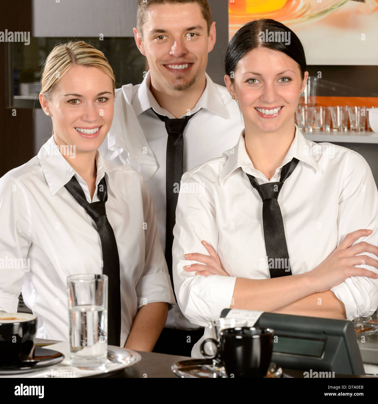 Three smiling server posing in uniform in cafe Stock Photo - Alamy