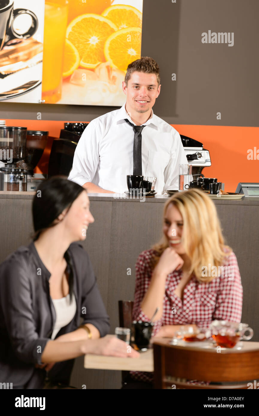Attractive bartender smiling in pub female customers talking Stock ...