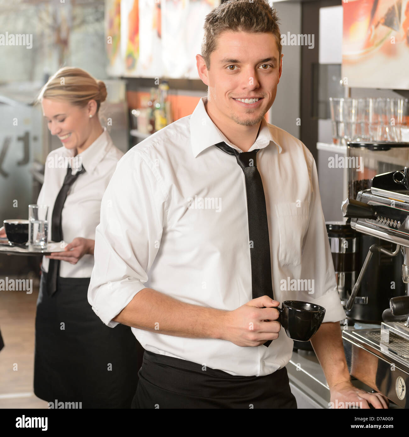 Handsome waiter making coffee with espresso machine in coffee house ...