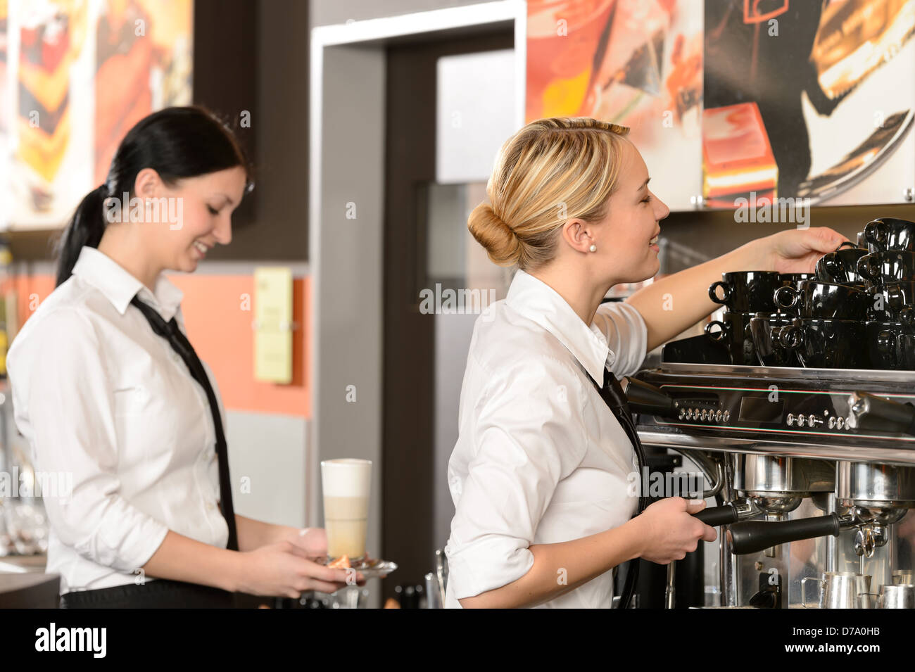 Two waitresses serving coffee with machine in shop Stock Photo - Alamy