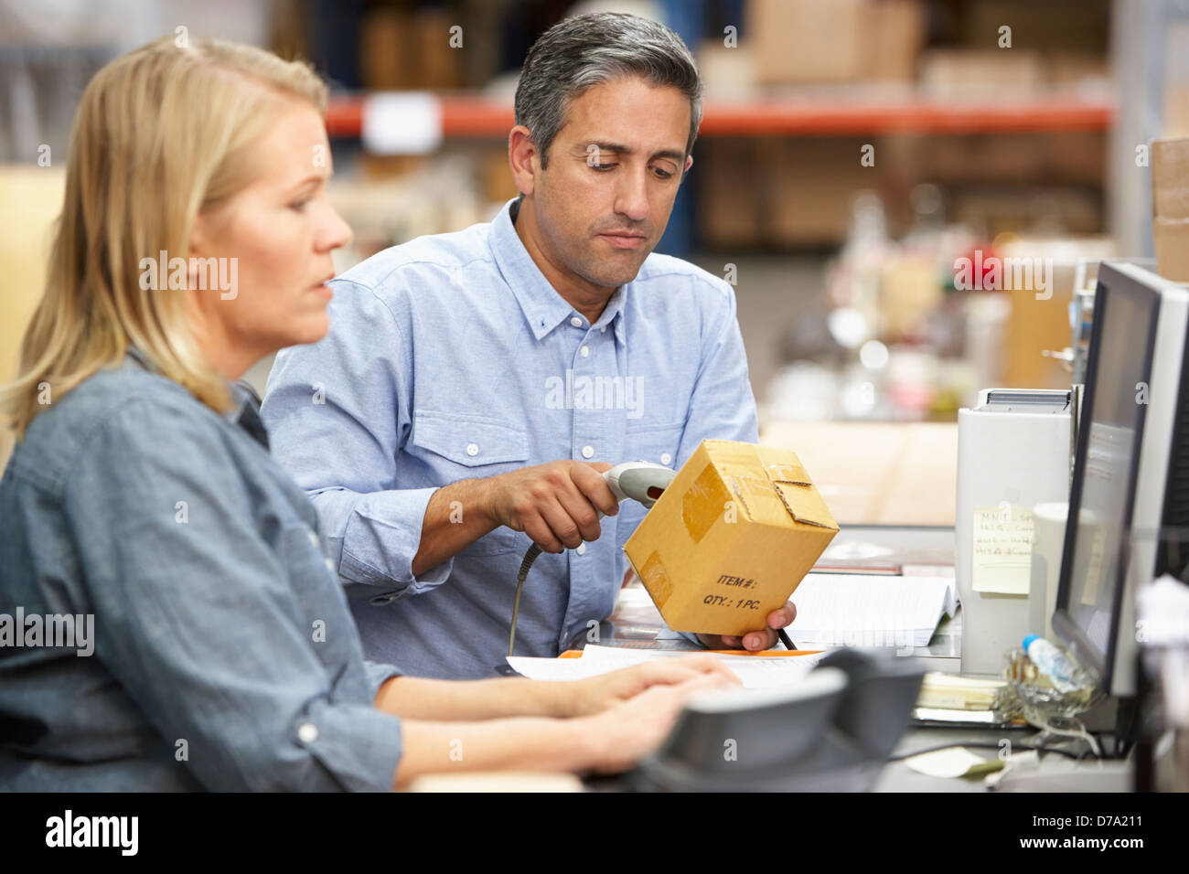 Business Colleagues Working At Desk In Warehouse Stock Photo - Alamy