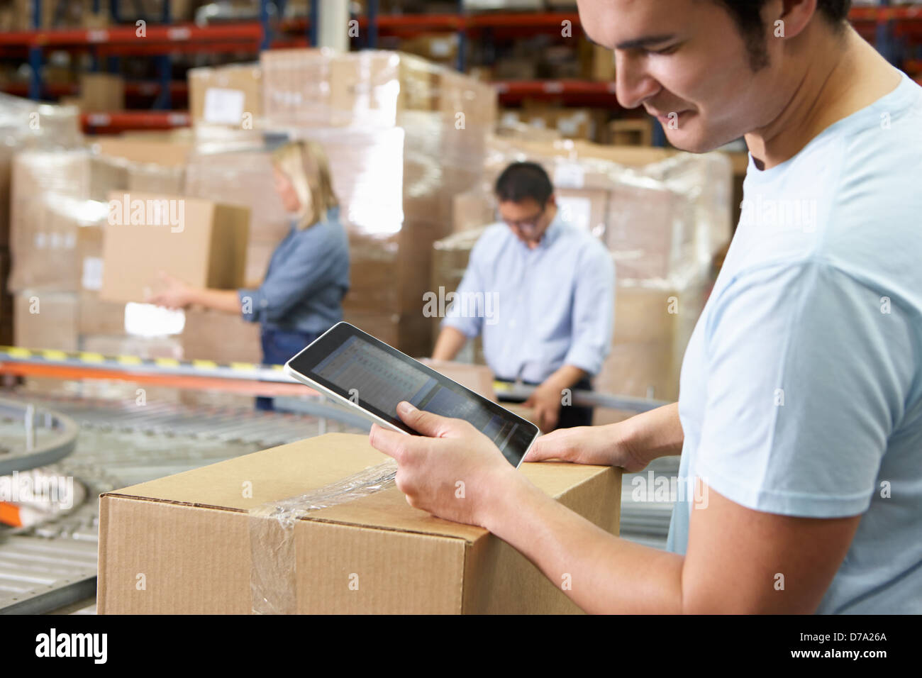 Worker Using Tablet Computer In Distribution Warehouse Stock Photo - Alamy