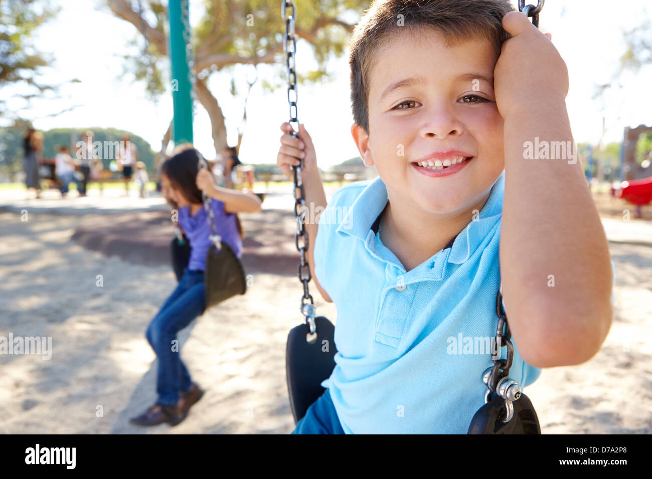 Boy And Girl Playing On Swing In Park Stock Photo - Alamy