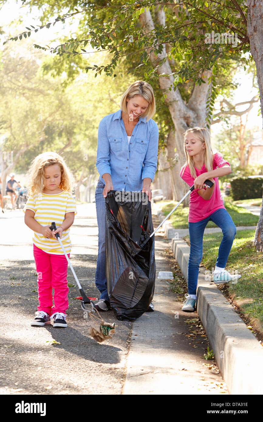 Mother And Daughters Picking Up Litter In Suburban Street Stock Photo ...