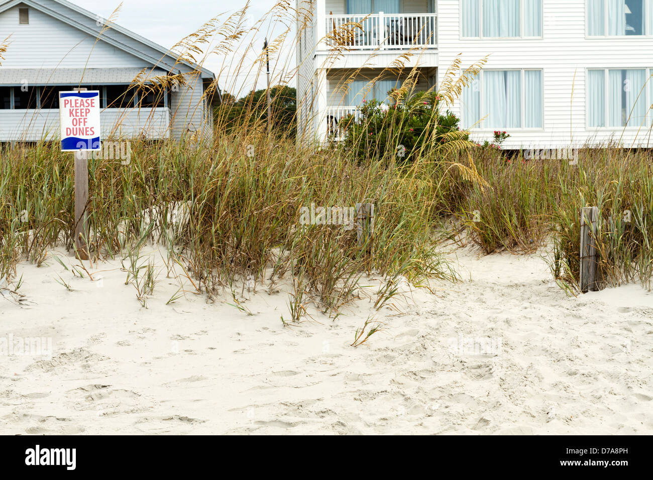 A " Please Keep Off Dunes" sign on the left with beach front houses in ...