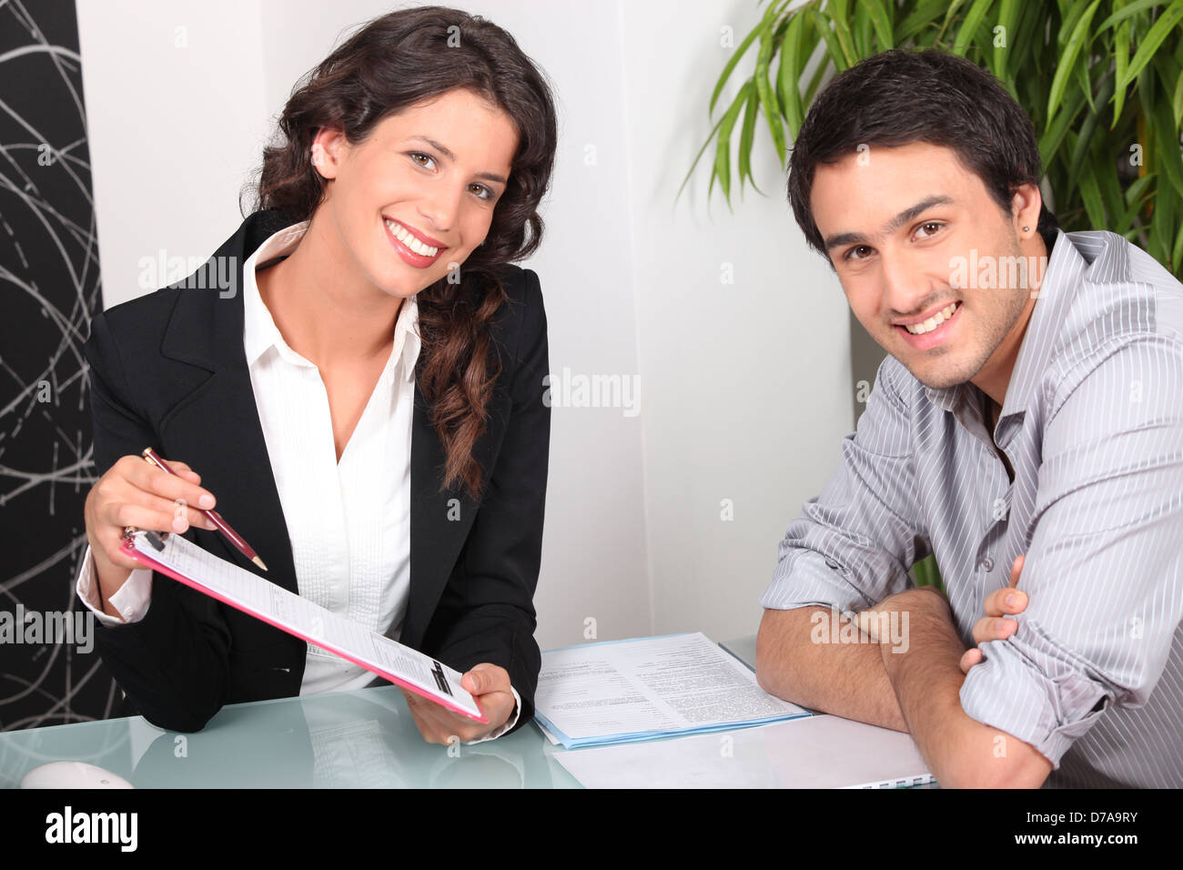 Woman explaining contract to customer Stock Photo - Alamy