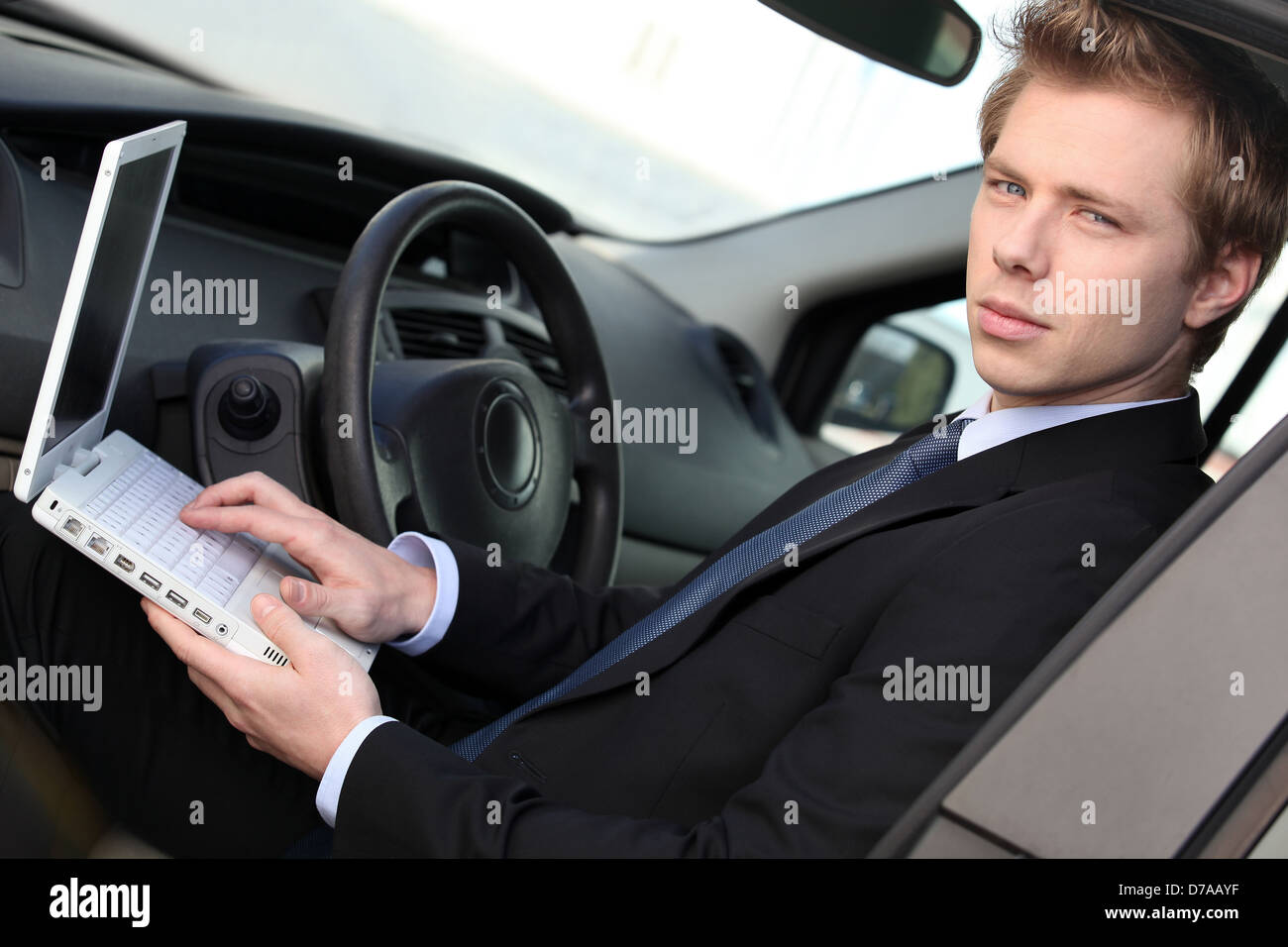 Man with computer in car Stock Photo - Alamy