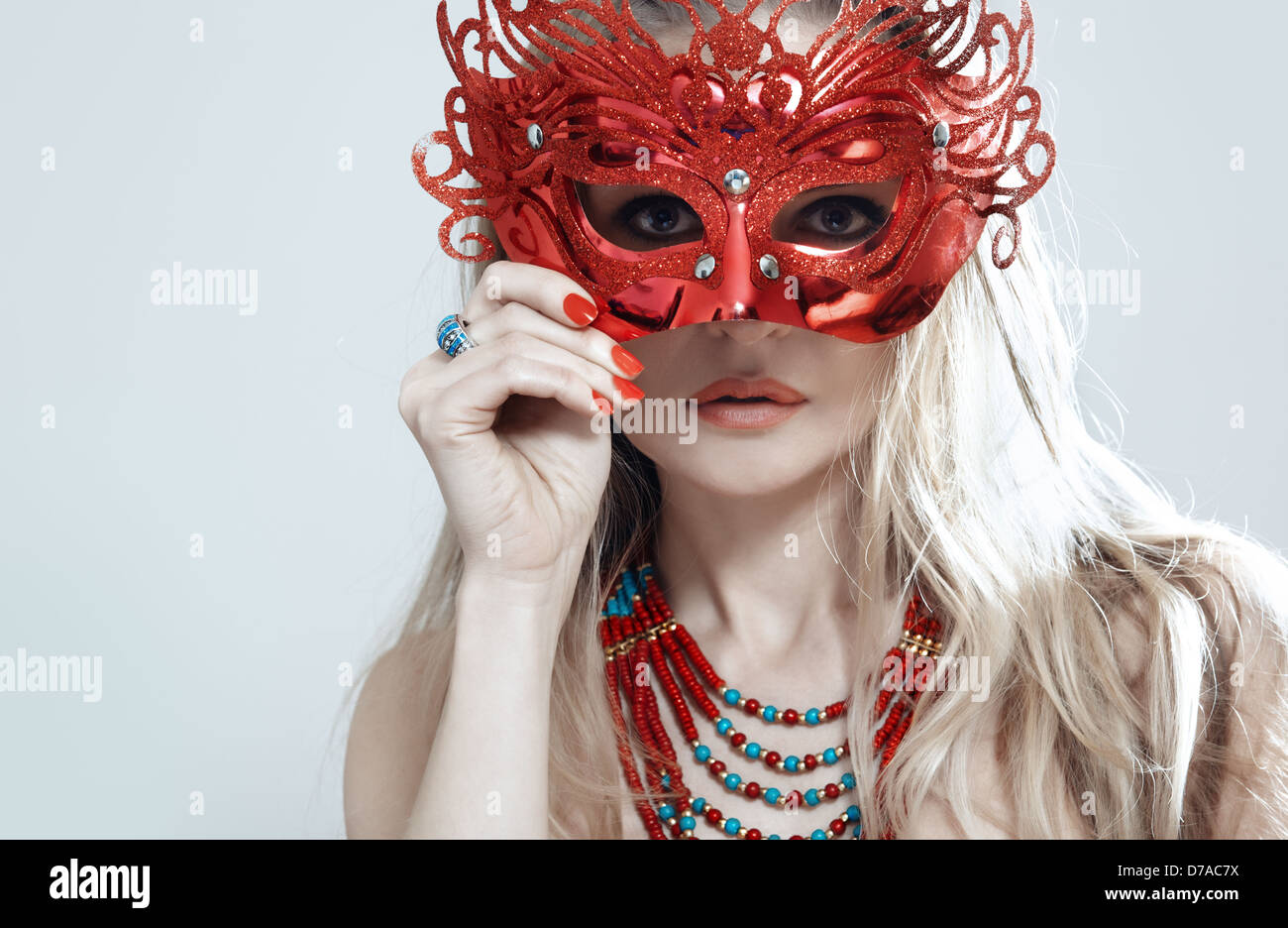 Blond lady in jewelry holding masquerade mask Stock Photo - Alamy