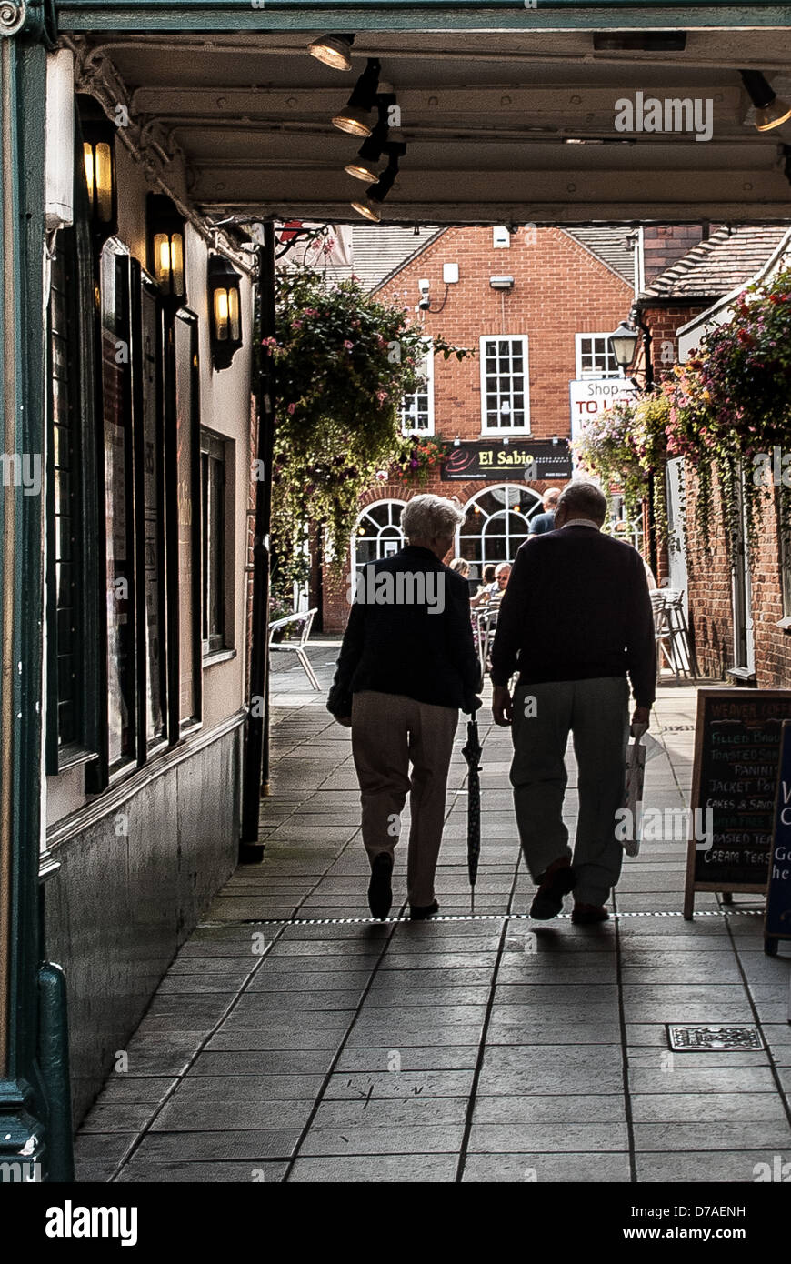 old couple walking away down old alley or passageway with walking ...