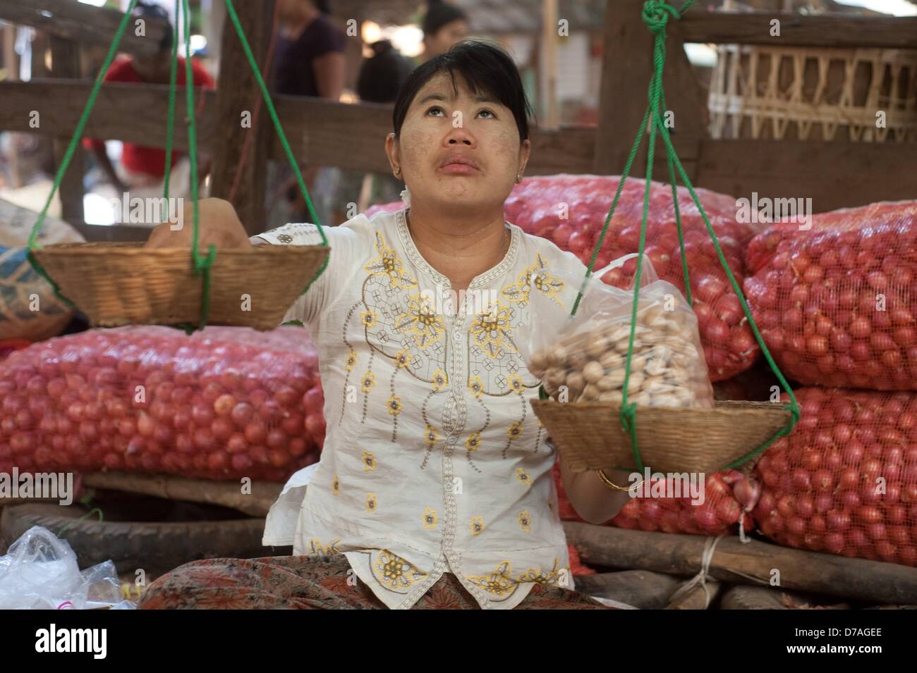 Myanmar A woman is using a pair of scales to measure the weight of ...