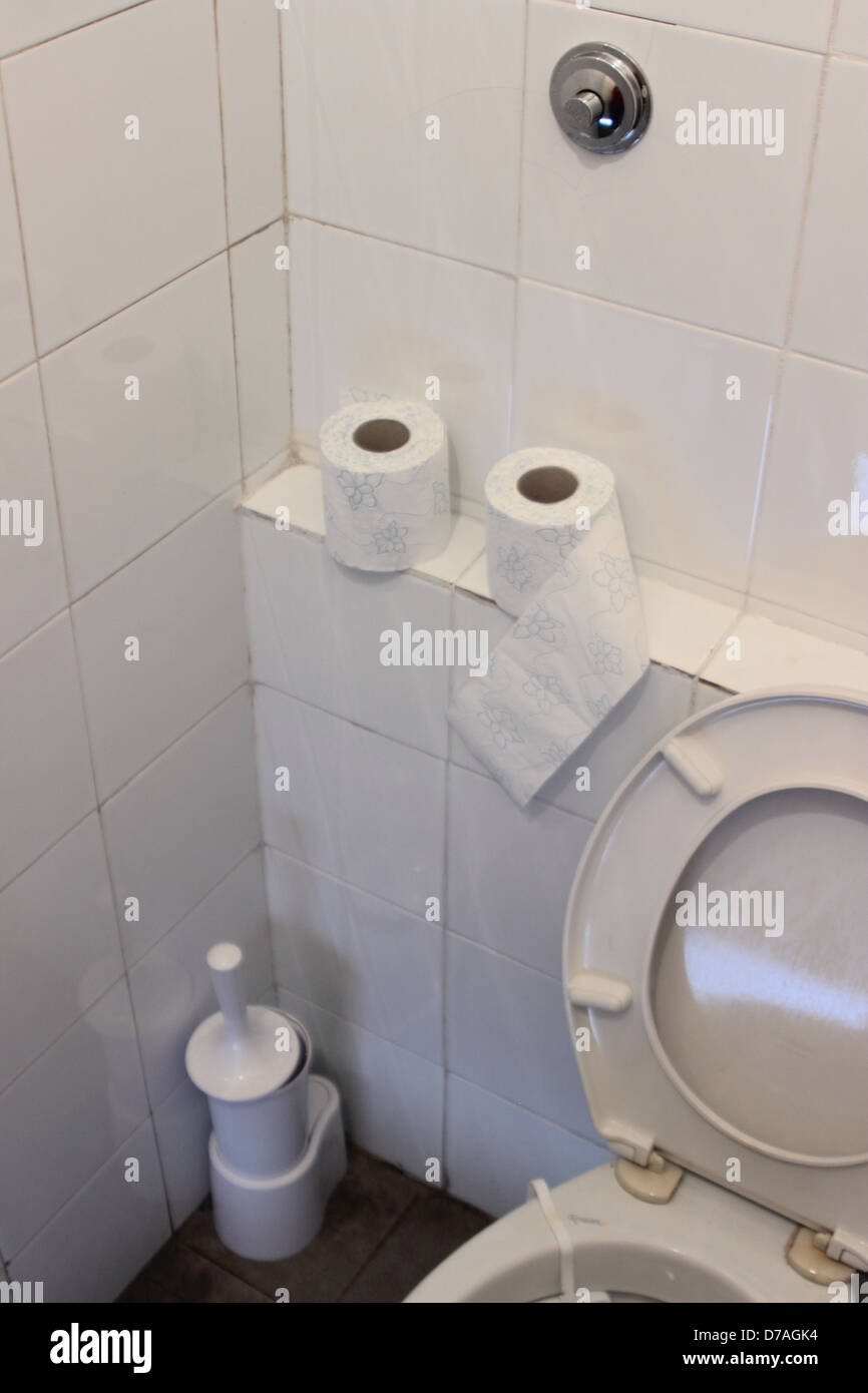 white public toilet and two rolls of toilet paper Stock Photo - Alamy