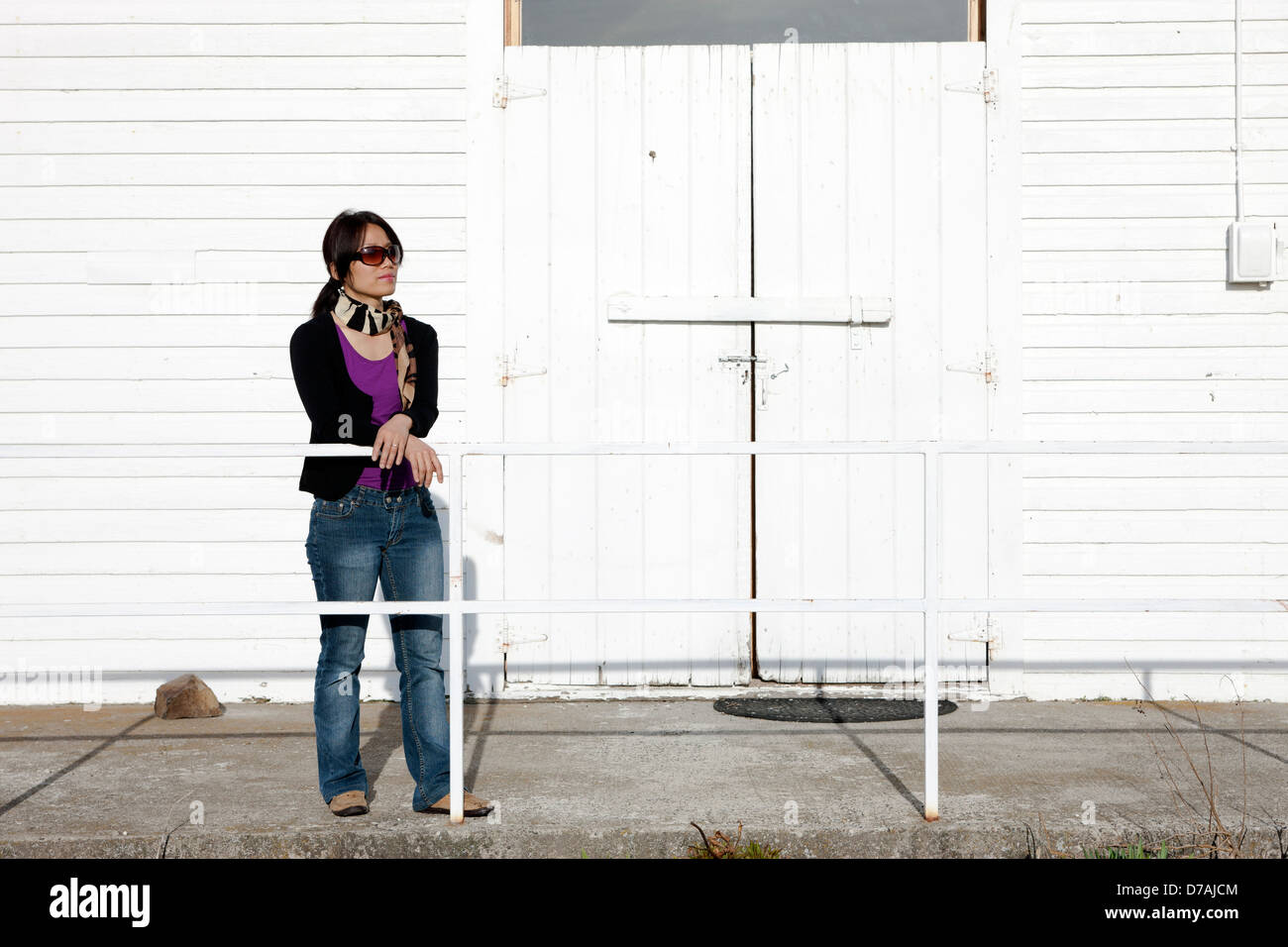 Pretty woman by white building Stock Photo - Alamy