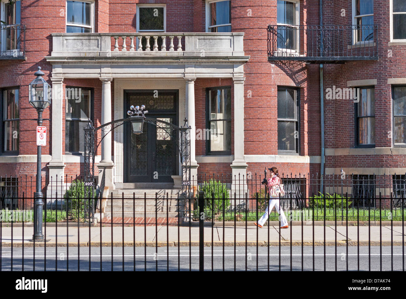 A woman walks past a red brick building in Boston Stock Photo - Alamy