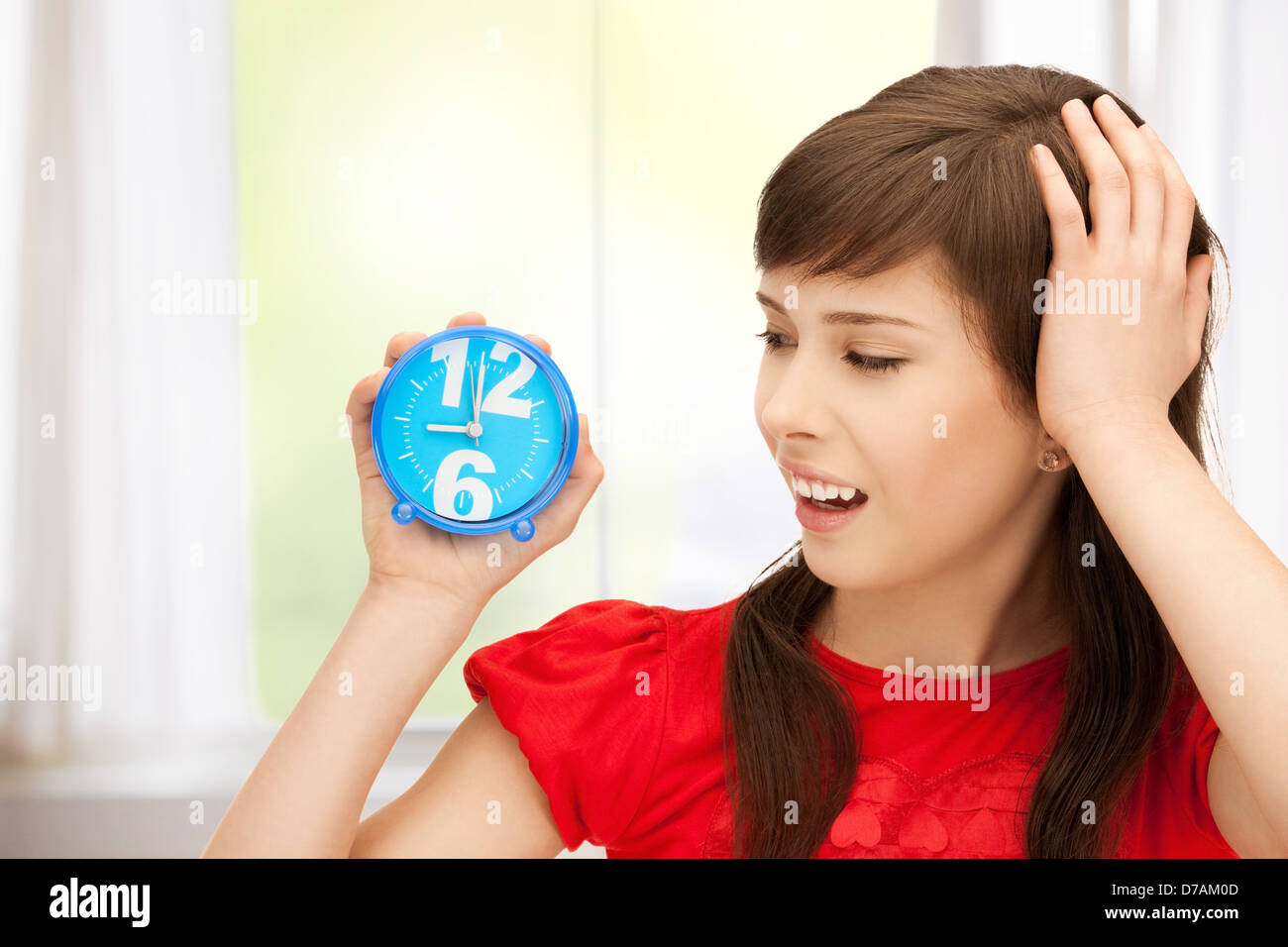 teenage girl holding alarm clock Stock Photo - Alamy