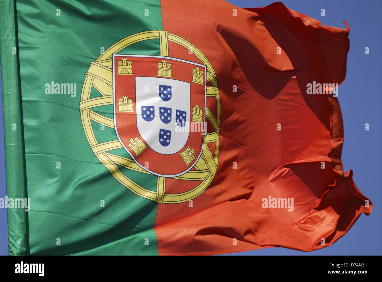 Portuguese flag blowing in the wind against blue sky Stock Photo - Alamy