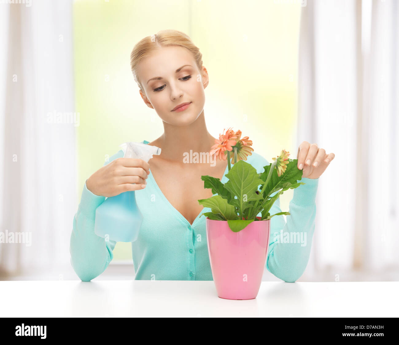 woman holding pot with flower and spray bottle Stock Photo - Alamy