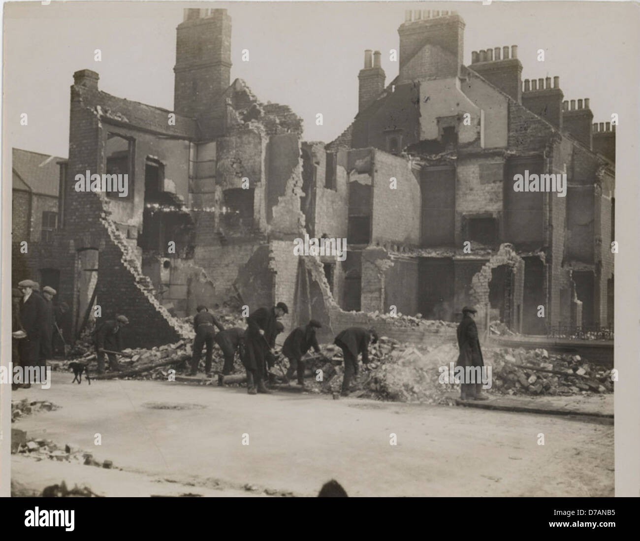 This image shows workers searching through rubble in the aftermath of a ...