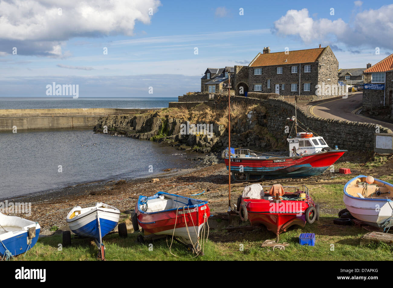 Craster harbour with small boats and a fishing boat, Northumberland ...