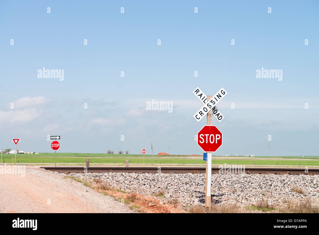 A railroad crossing sign next to a dirt road in rural Oklahoma, USA ...