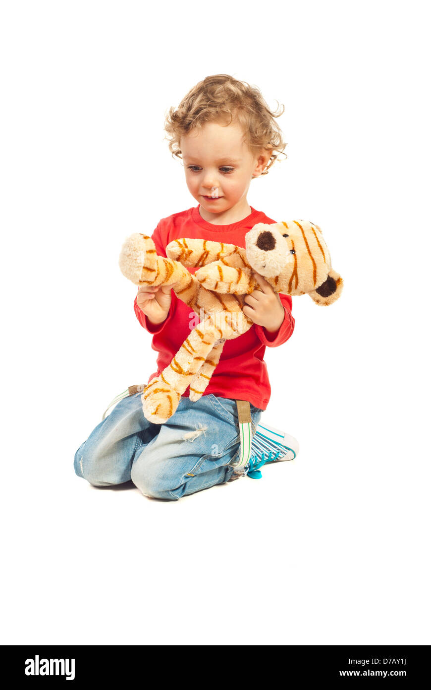 Little blond boy playing with tiger toy isolated on white background ...
