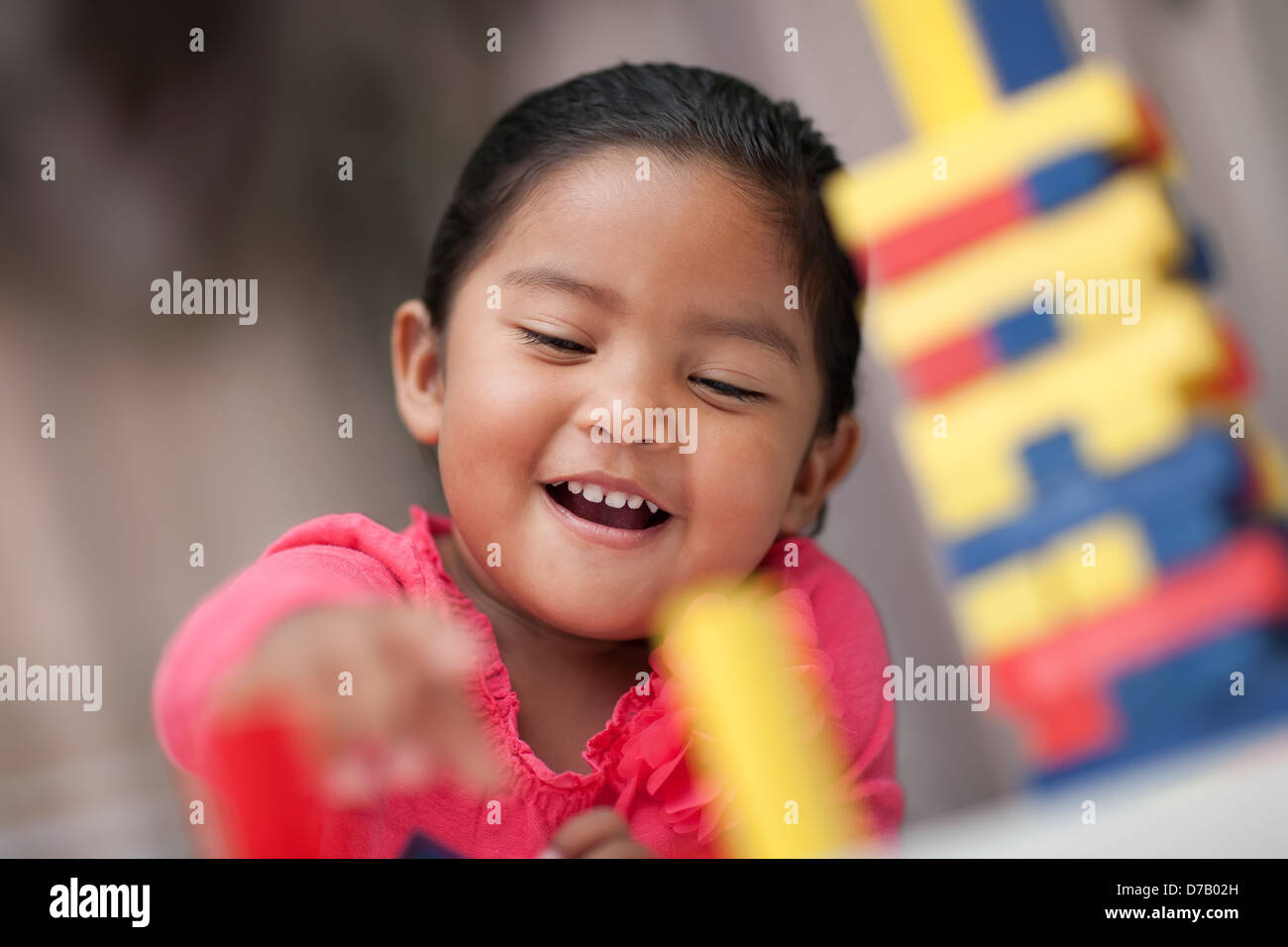 Toddler reaching for a colorful building block toy Stock Photo - Alamy