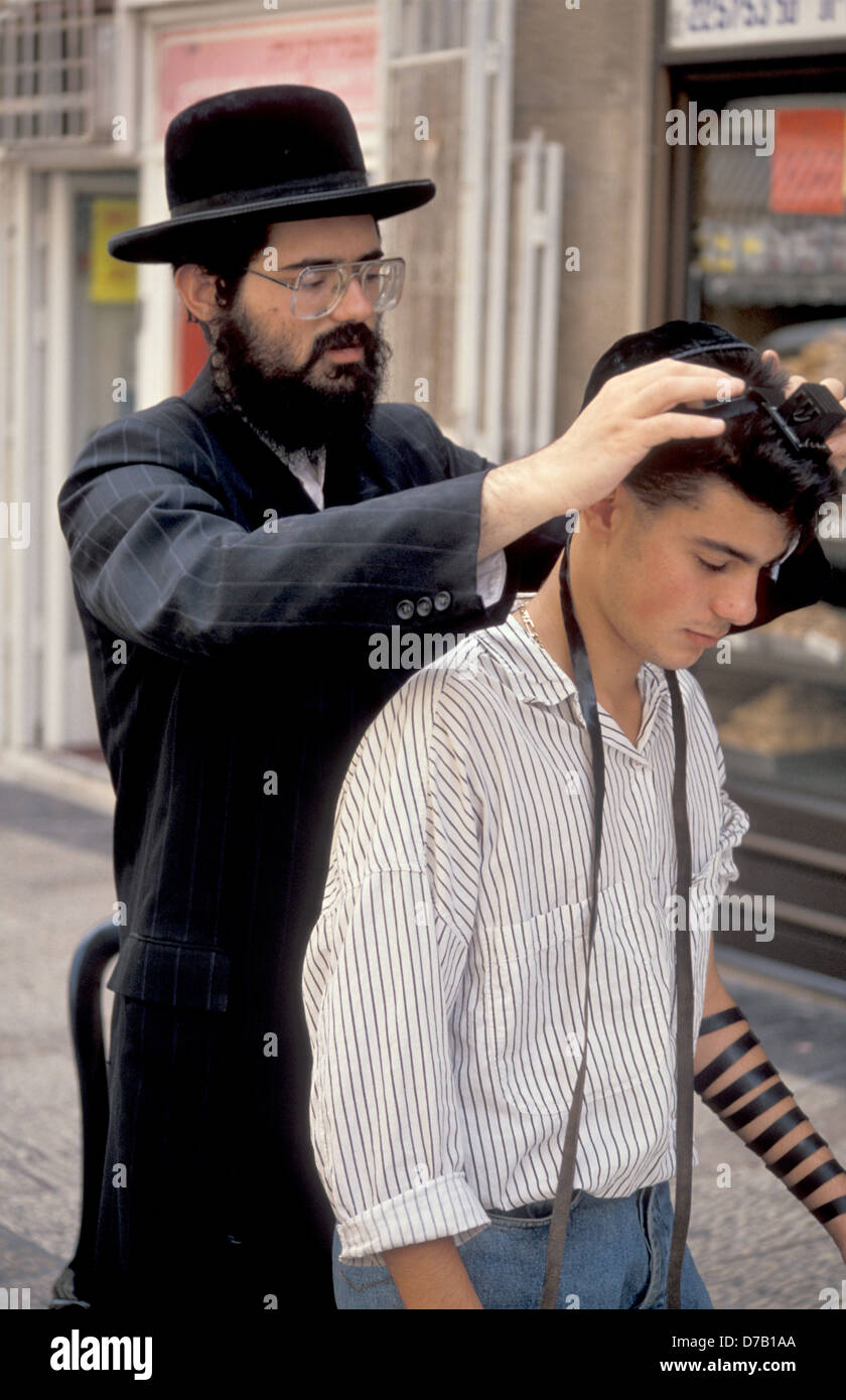 Hassid helping boy to lay Tefillin Stock Photo - Alamy